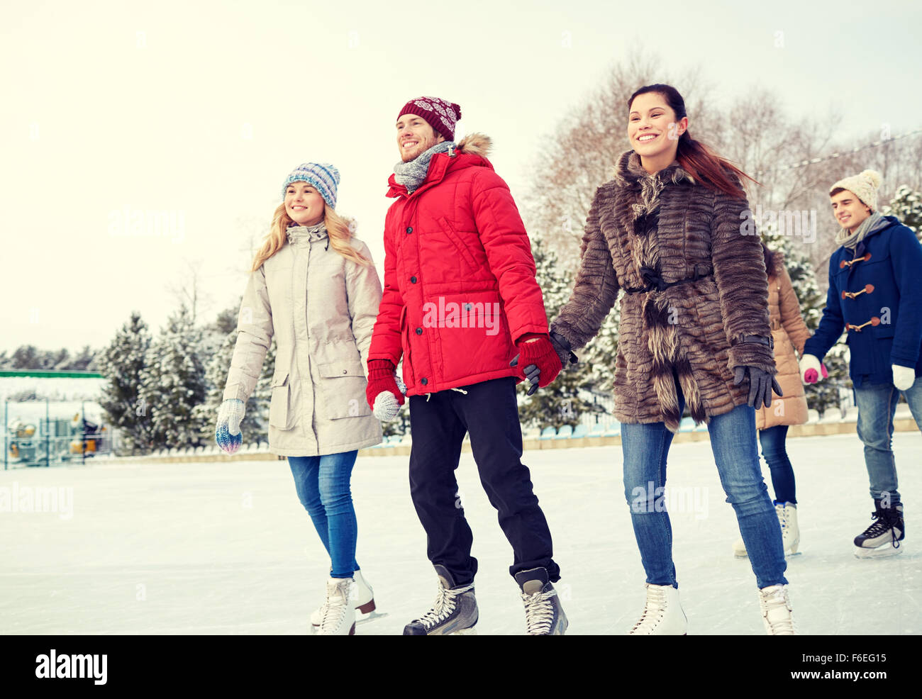 happy friends ice skating on rink outdoors Stock Photo - Alamy
