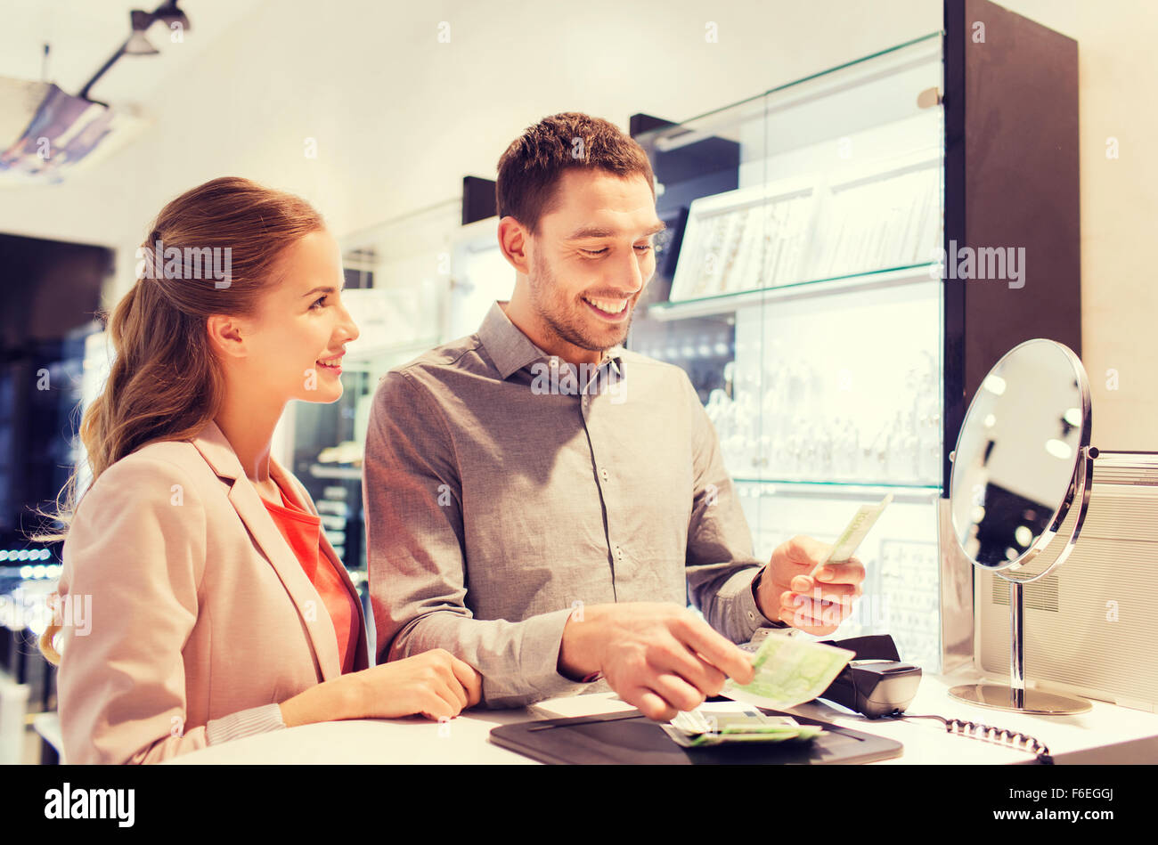 happy couple paying for purchase in store Stock Photo - Alamy