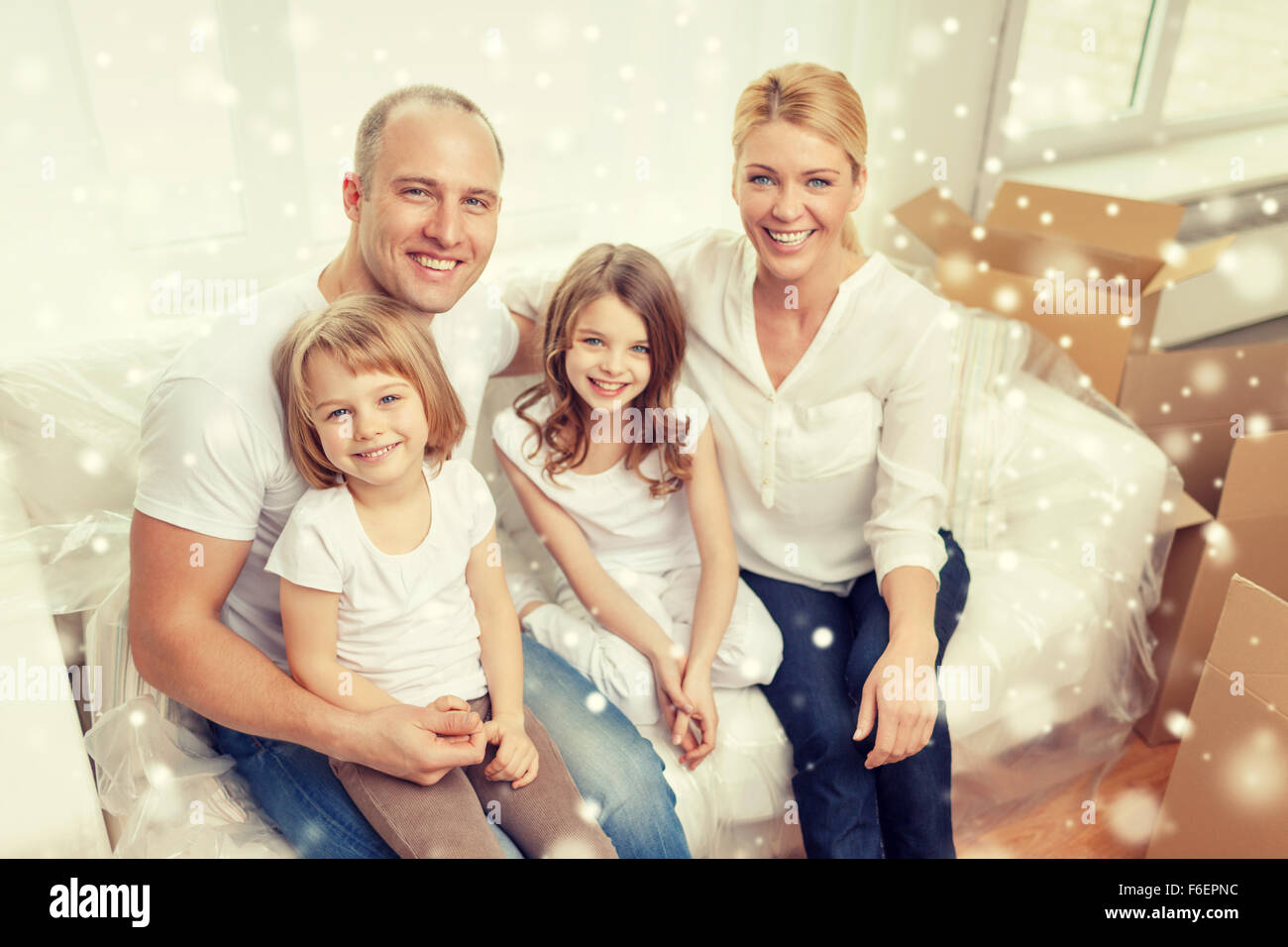 smiling parents and two little girls at new home Stock Photo - Alamy