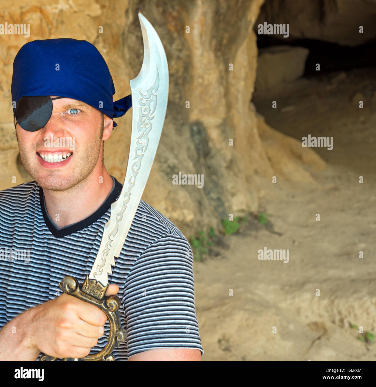 Angry male pirate with sword near the cave entrance. Place for your ...