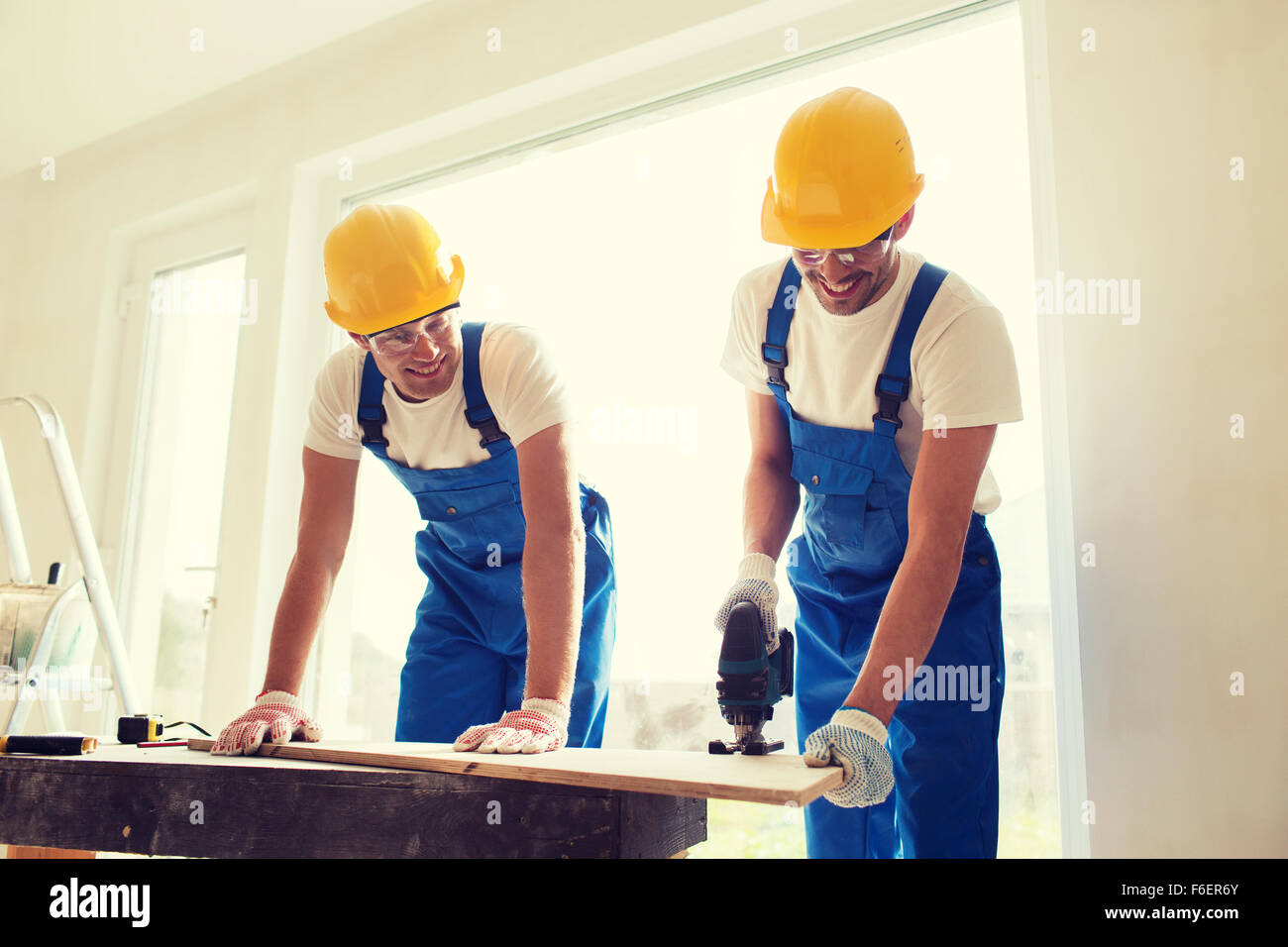 group of builders with tools indoors Stock Photo - Alamy