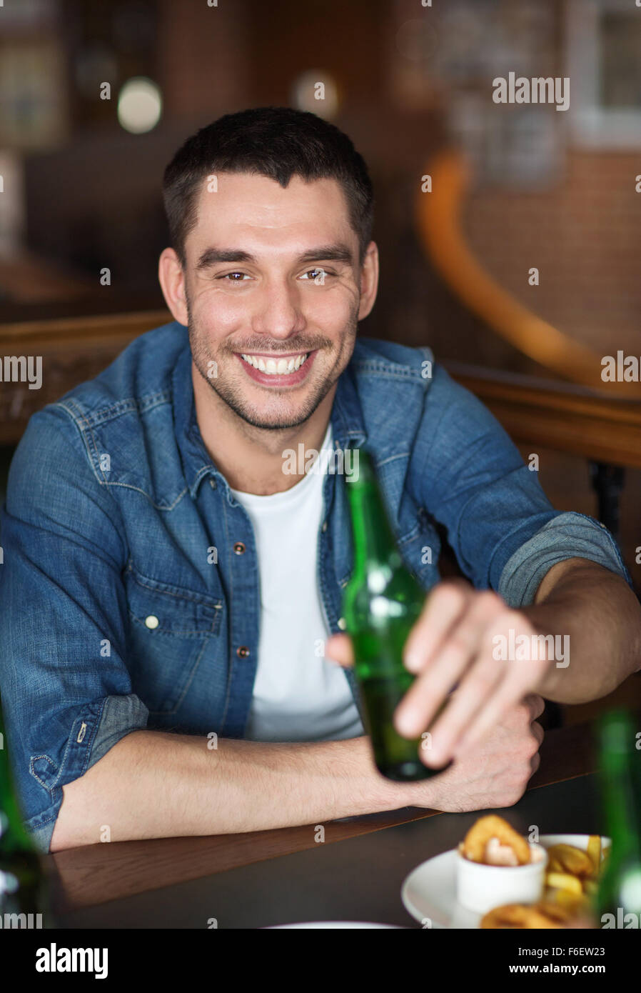 happy young man drinking beer at bar or pub Stock Photo - Alamy