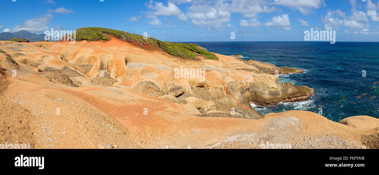 Green water, waves and sun around the Red Rocks of Calibishie Stock ...