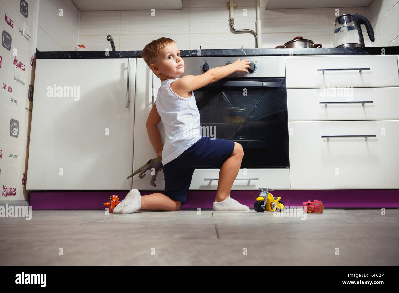 accident prevention. The child unattended playing in the kitchen with a ...