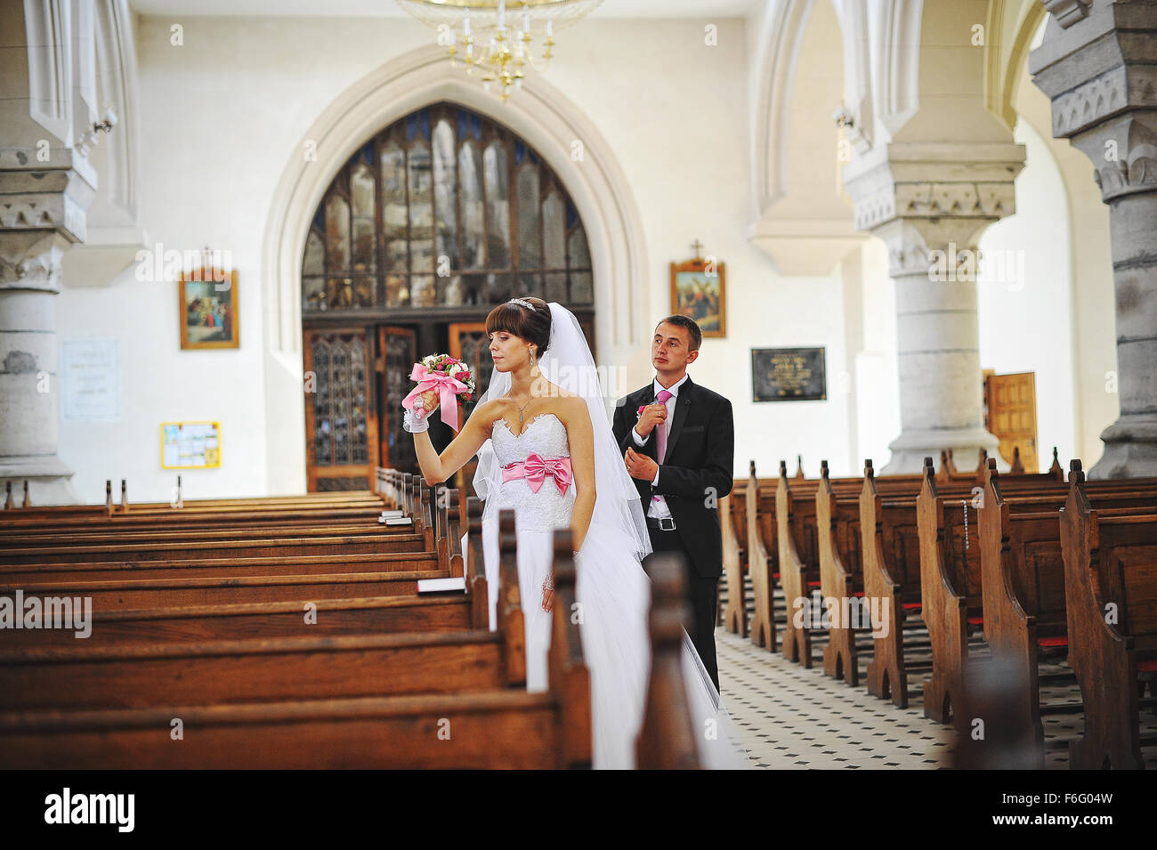 Young beautiful wedding couple at the old catholic church Stock Photo ...