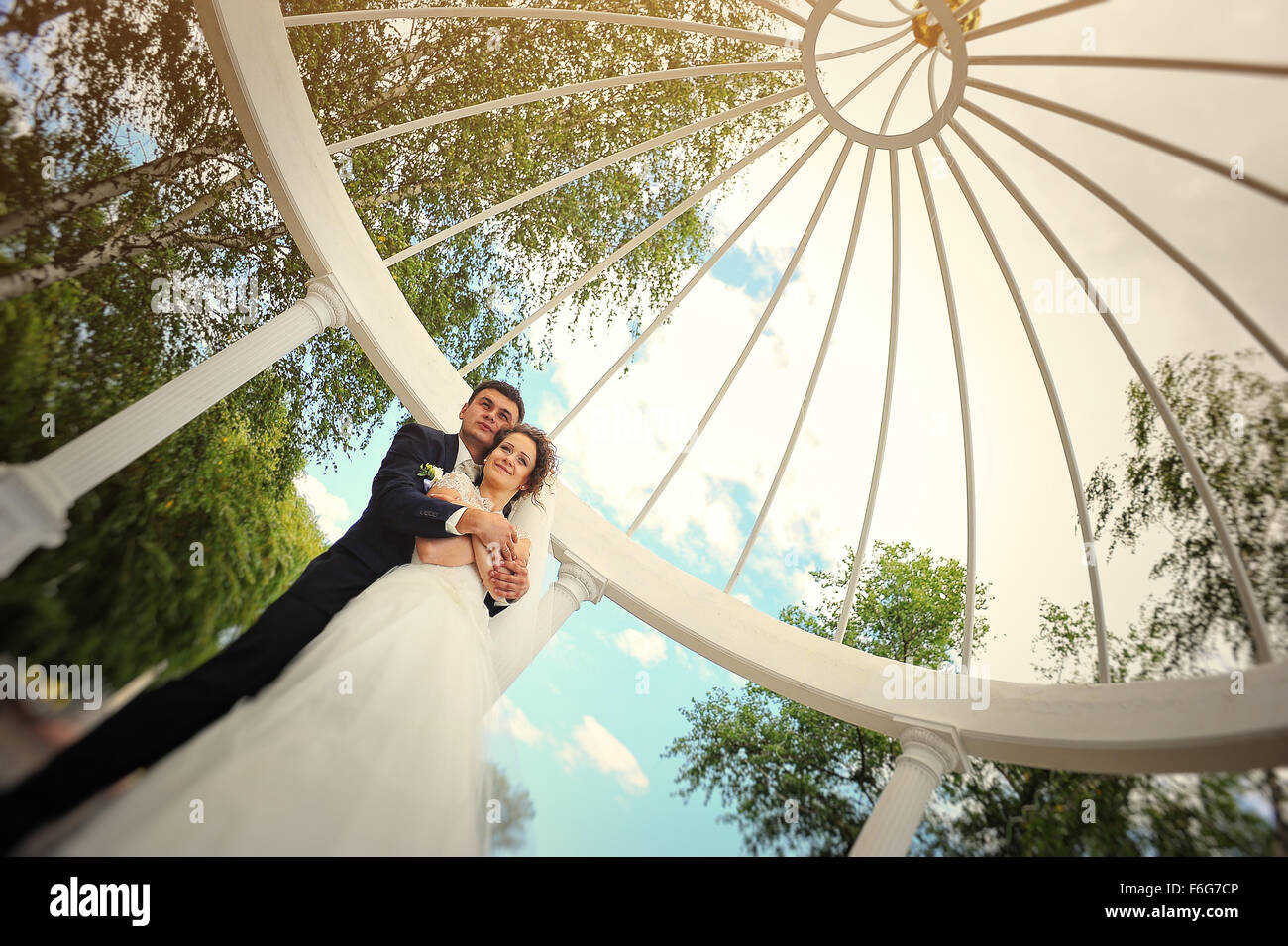 wedding couple under white arch Stock Photo - Alamy