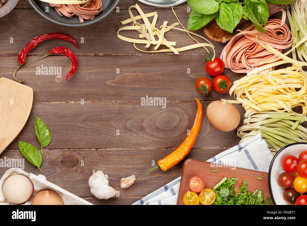 Pasta cooking ingredients and utensils on wooden table. Top view with ...