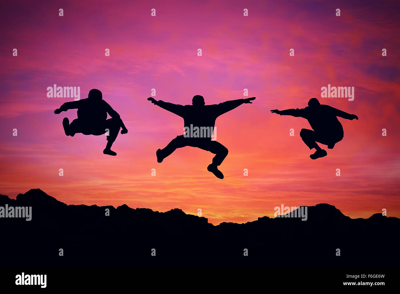 Three boys jump over a mountain sunset Stock Photo - Alamy