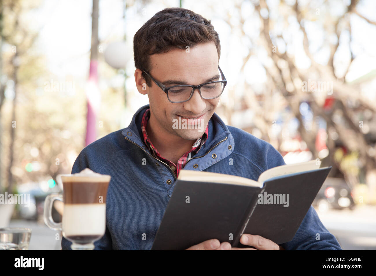 Man reading a book while drinking a coffee Stock Photo - Alamy