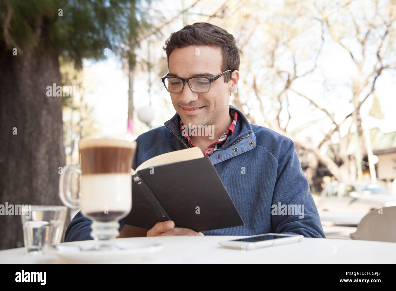 Man reading a book while drinking a coffee Stock Photo - Alamy