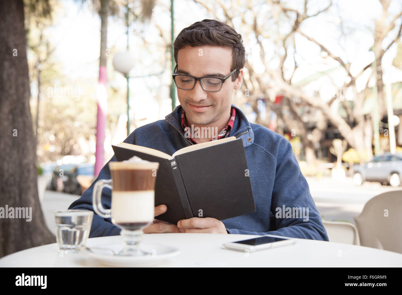 Man reading a book while drinking a coffee Stock Photo - Alamy
