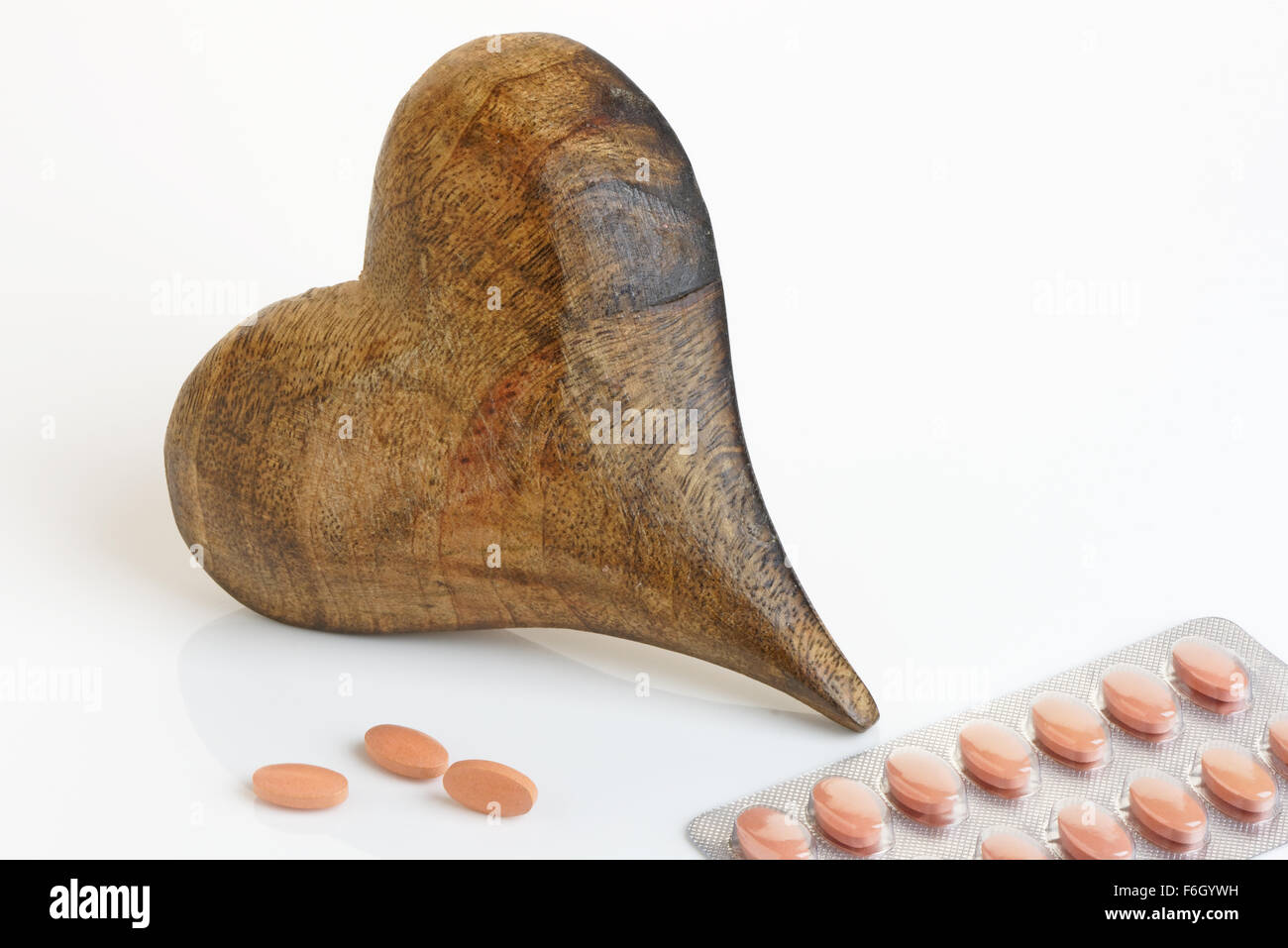 Generic pack of statins or other heart medication with a wooden heart ...