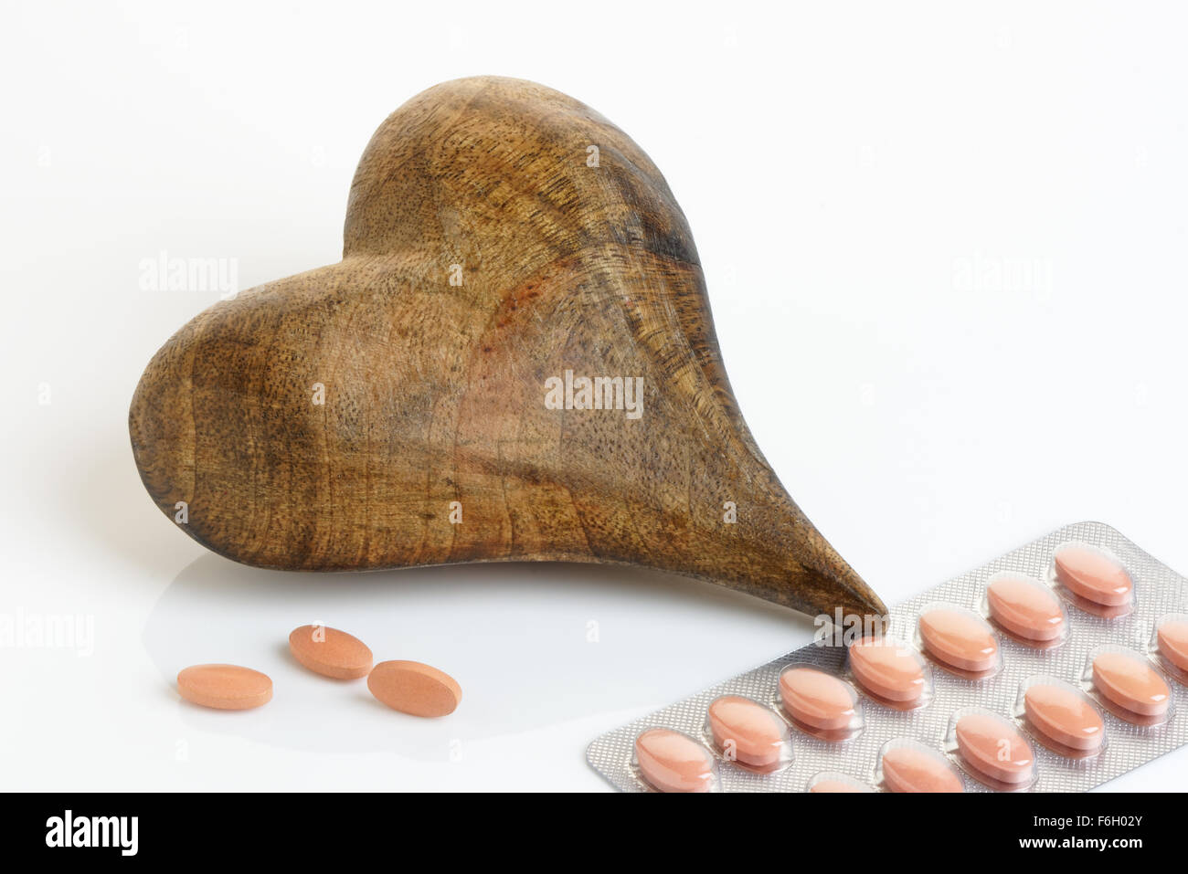 Generic pack of statins or other heart medication with a wooden heart ...