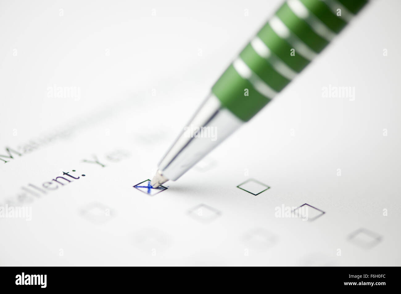 Closeup of a green pen tick a form with English writing "Yes" with very ...