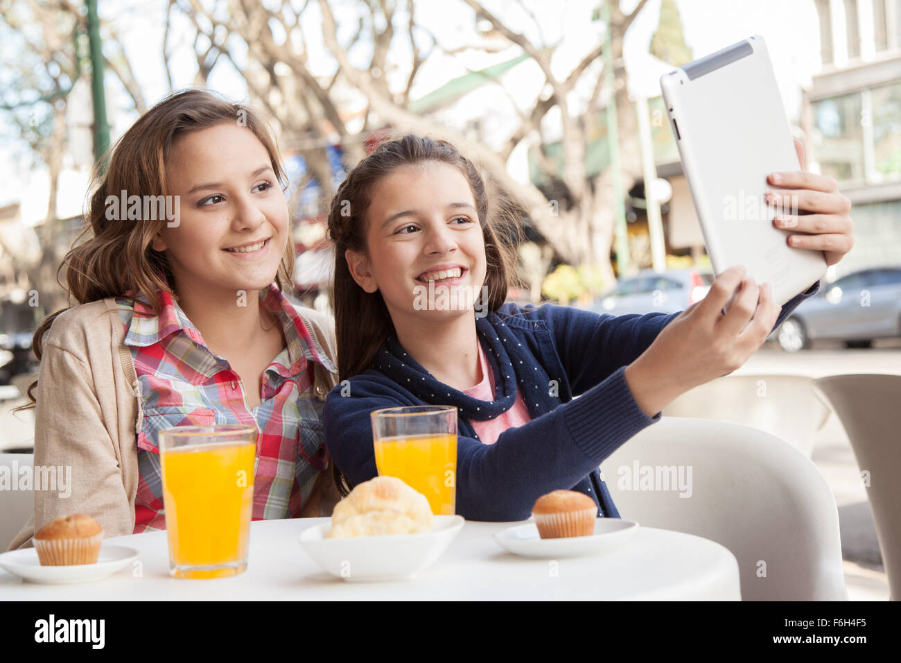 Two girls playing with the tablet Stock Photo - Alamy