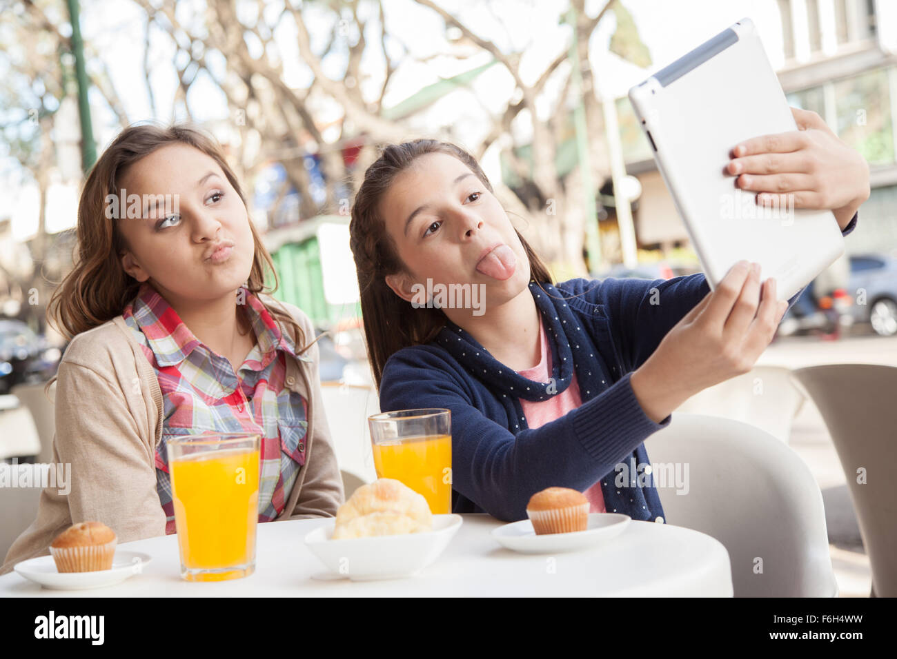 Two girls playing with the tablet Stock Photo - Alamy