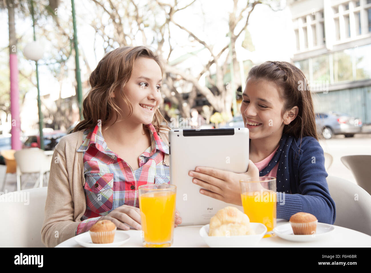 Two girls playing with the tablet Stock Photo - Alamy