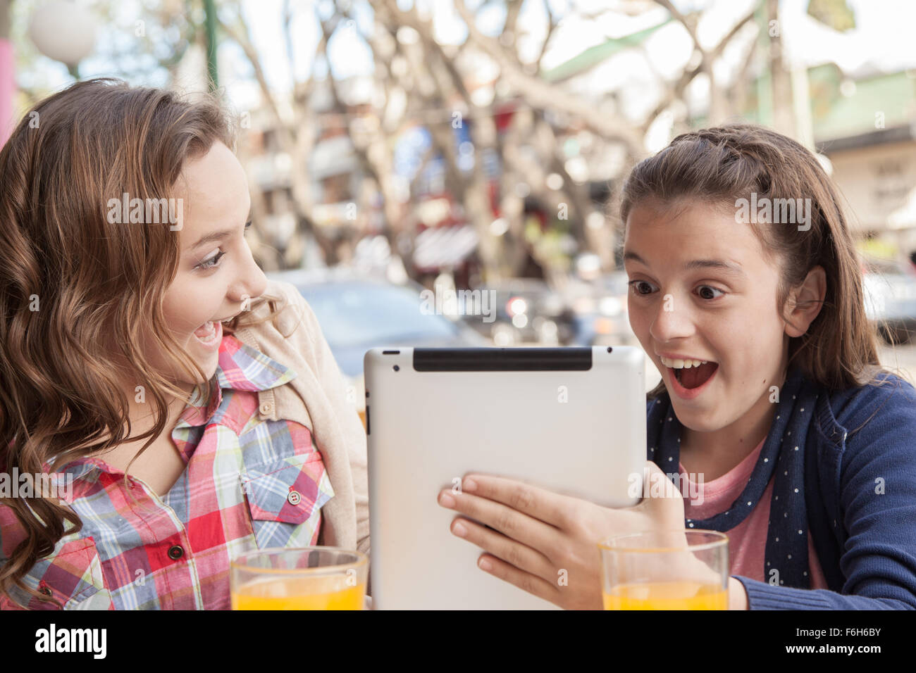 Two girls playing with the tablet Stock Photo - Alamy
