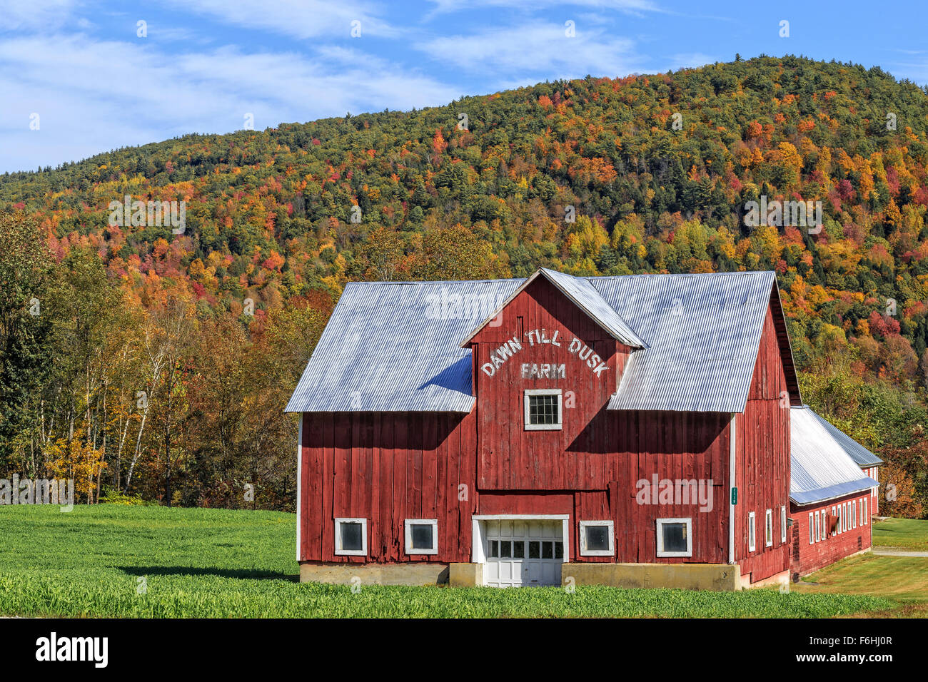 A bright red barn among the colorful fall autumn foliage in the state ...