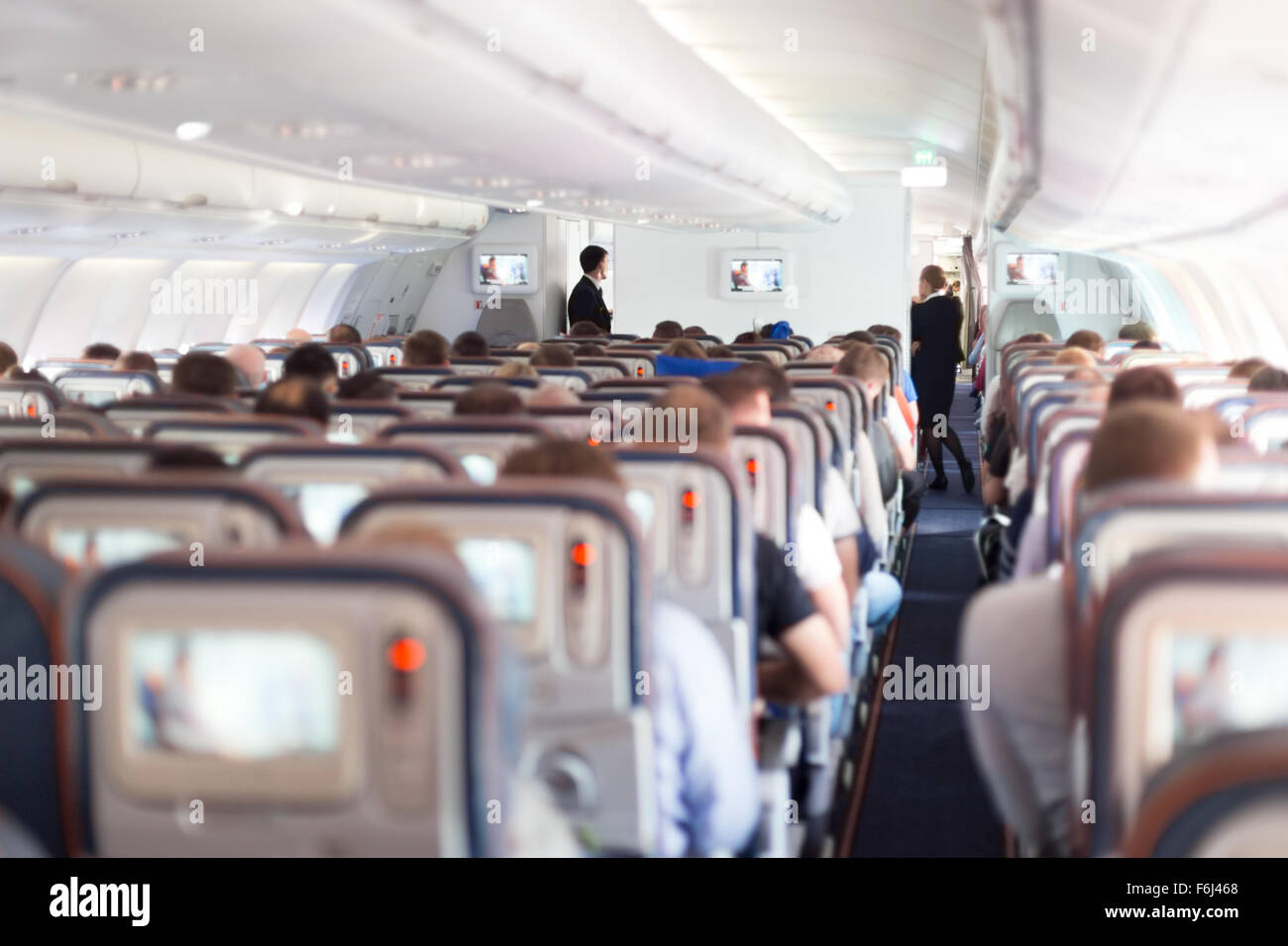 Interior of airplane with passengers on seats Stock Photo - Alamy