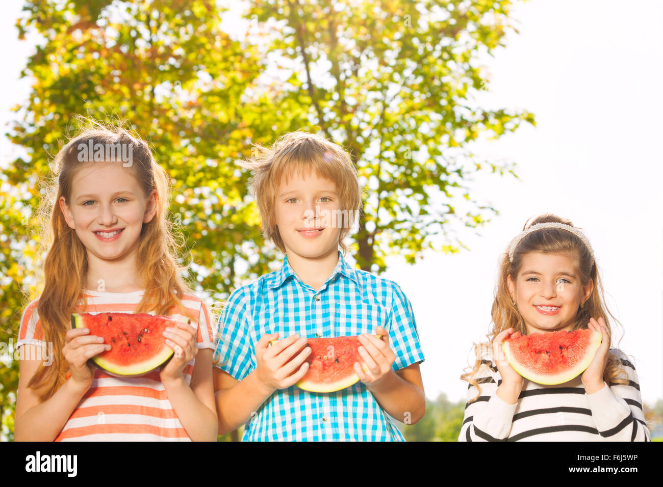 Friends hold watermelon and eating together in row Stock Photo - Alamy