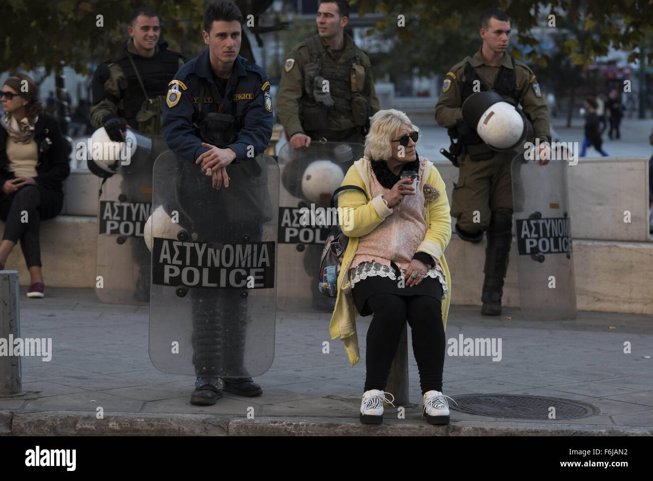 Athens, Greece. 17th Nov, 2015. A lady rests next to riot policemen ...