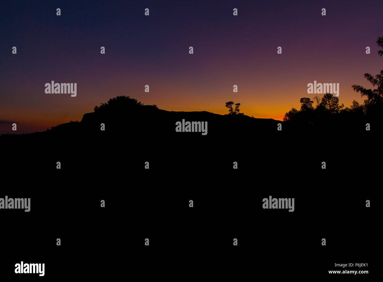 purple and orange African sunset over the horizon of some rocks and ...