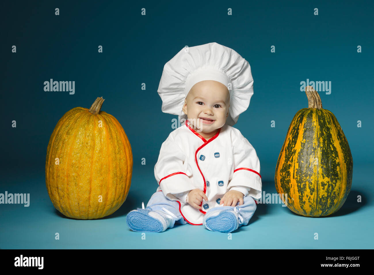 funny baby with cook costume holds pumpkin Stock Photo - Alamy