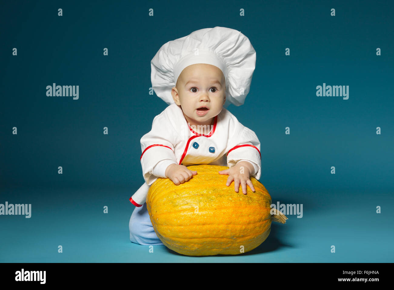 funny baby with cook costume holds pumpkin Stock Photo - Alamy