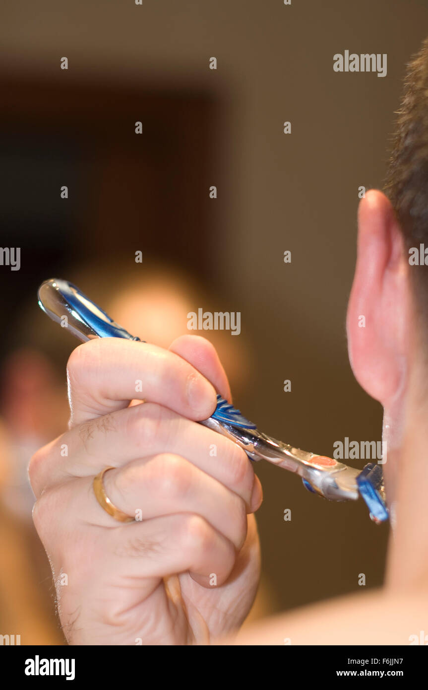 Man shaving himself in front of a mirror Stock Photo - Alamy