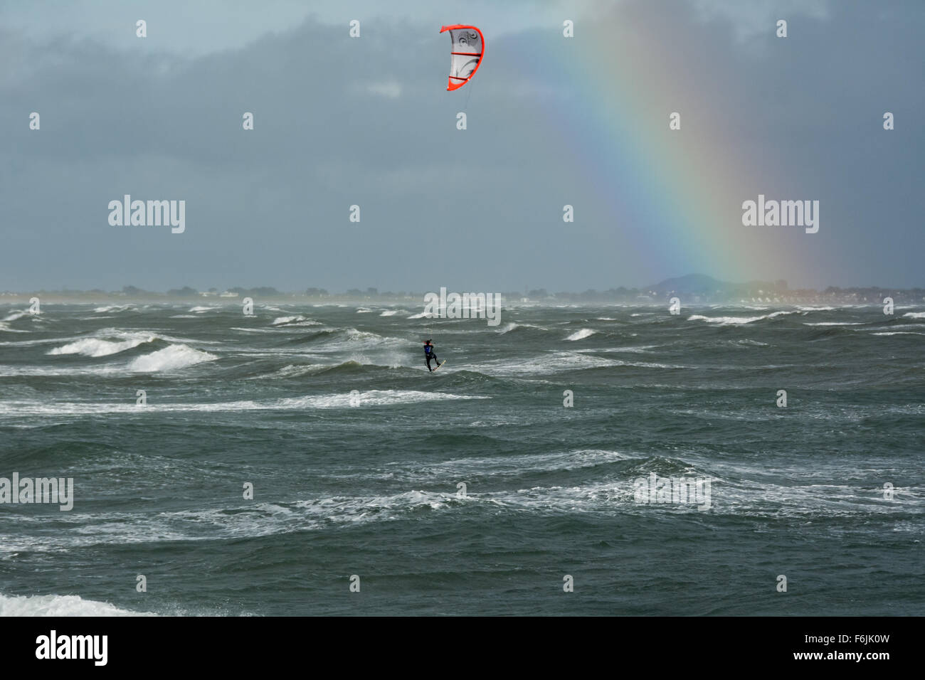 Para surfing off Bull Island,Dublin, in the Irish sea with a rainbow in ...