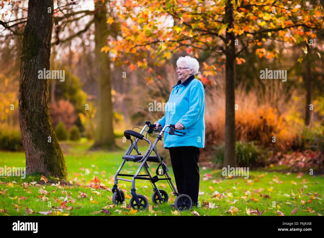Happy senior handicapped lady with a walking disability enjoying a walk ...