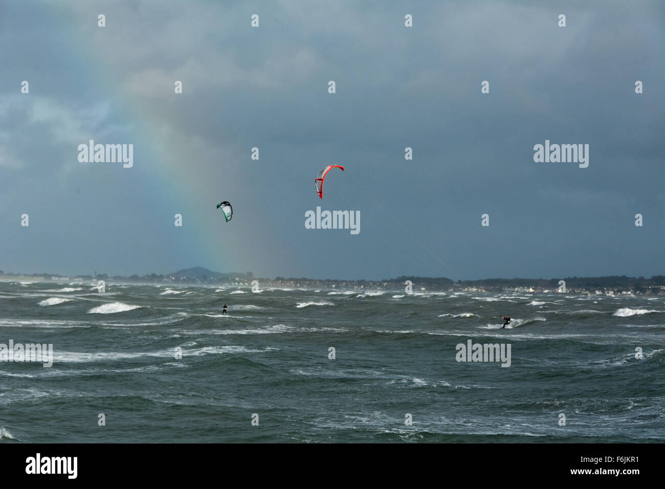 Para surfing off Bull Island,Dublin, in the Irish sea with a rainbow in ...
