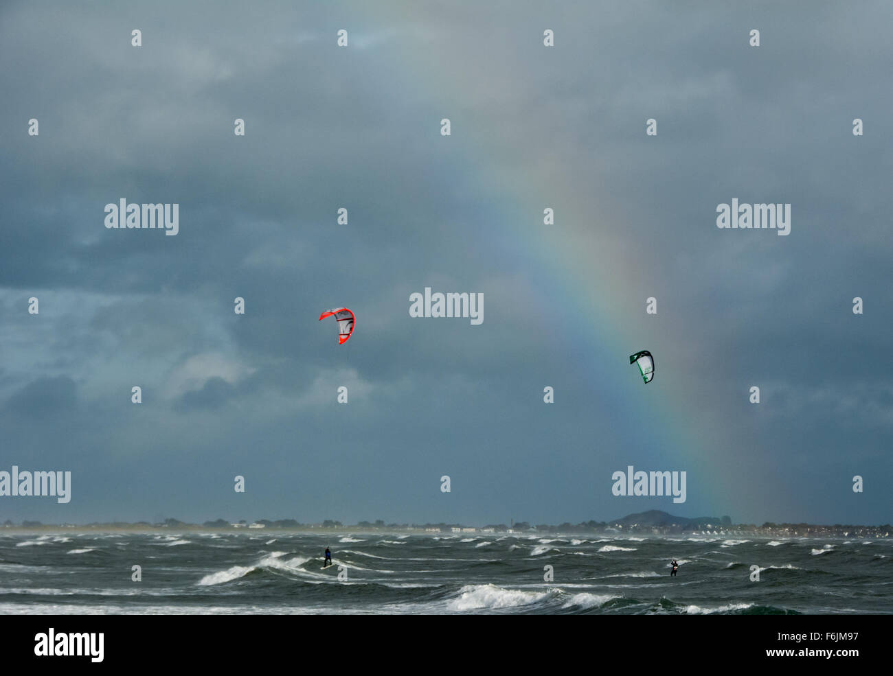 Para surfing off Bull Island,Dublin, in the Irish sea with a rainbow in ...