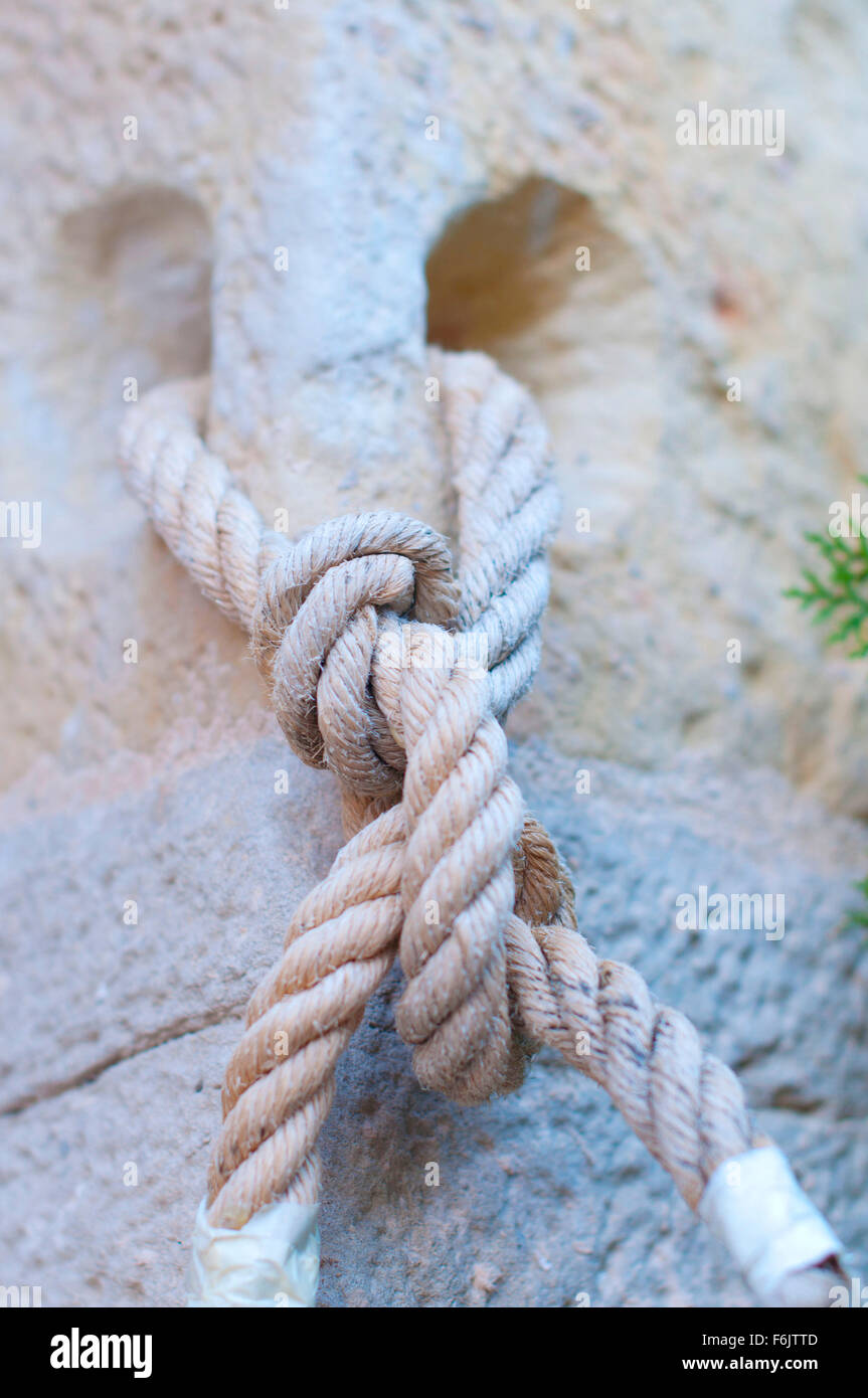 Knot in a rope in a wall hole Stock Photo - Alamy