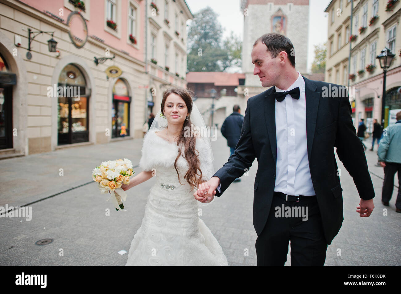 Young elegant and hearty wedding couple in love on streets of Krakow ...
