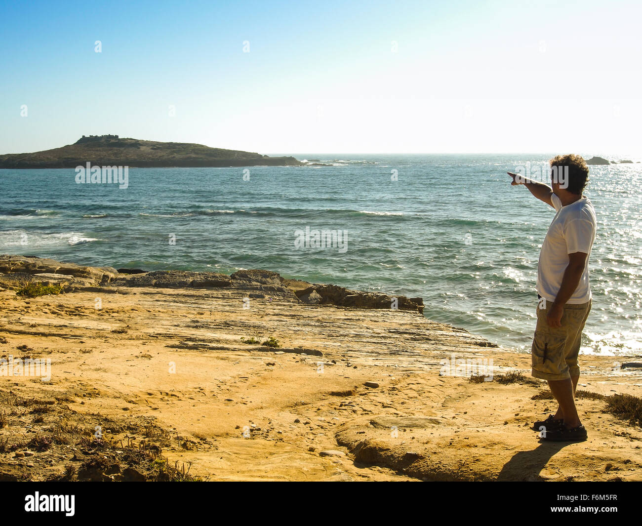 caucasian man pointing to the island in the ocean Stock Photo - Alamy