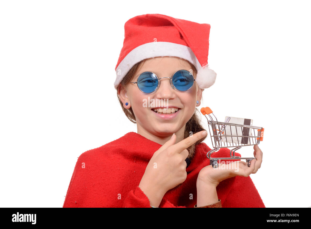 Cute little girl Santa Claus giving credit card and small shopping cart ...