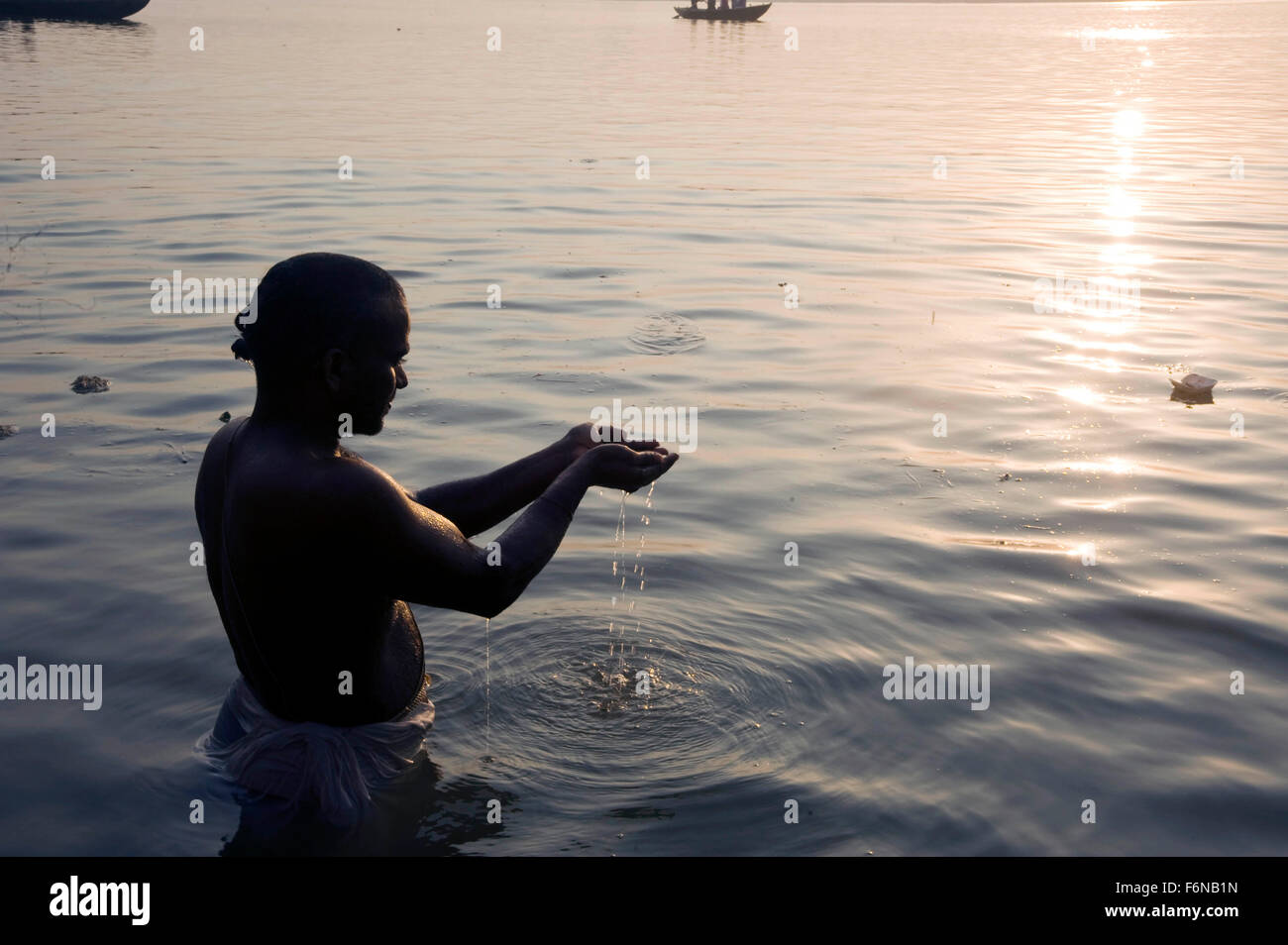 Pilgrim performing puja in ganga river, varanasi, uttar pradesh, india ...
