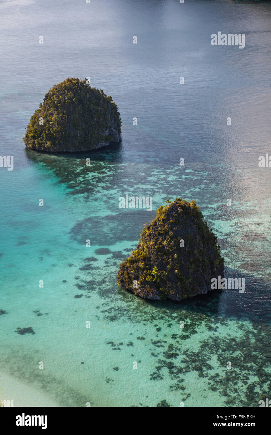 Limestone islands surrounded by a coral reef in a remote part of Raja ...