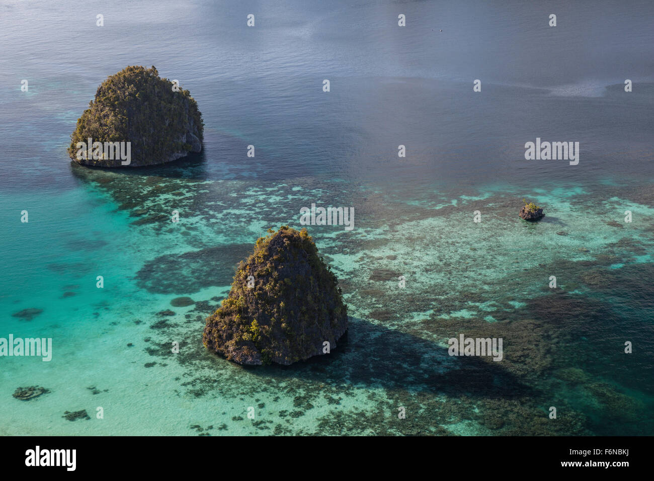 Limestone islands surrounded by a coral reef in a remote part of Raja ...