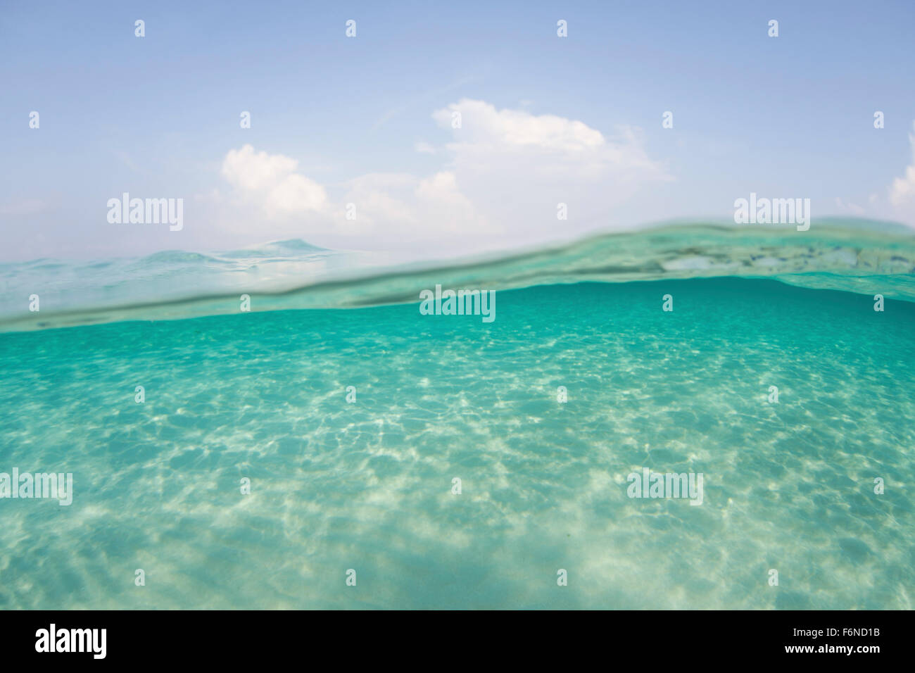 Sunlight ripples across a shallow sand flat in Indonesia. This tropical ...