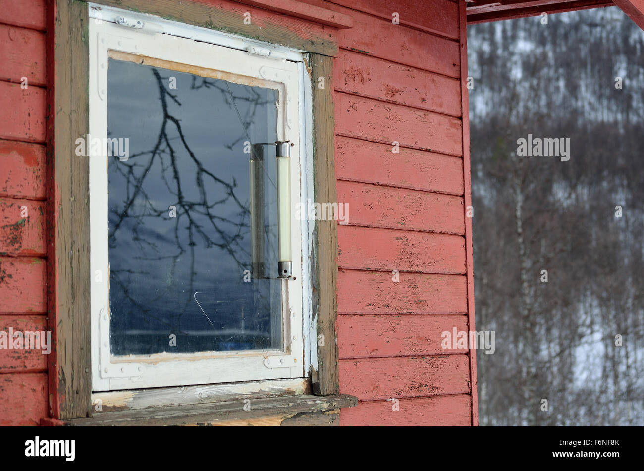 small red hut with tree and mountain reflection in window Stock Photo ...