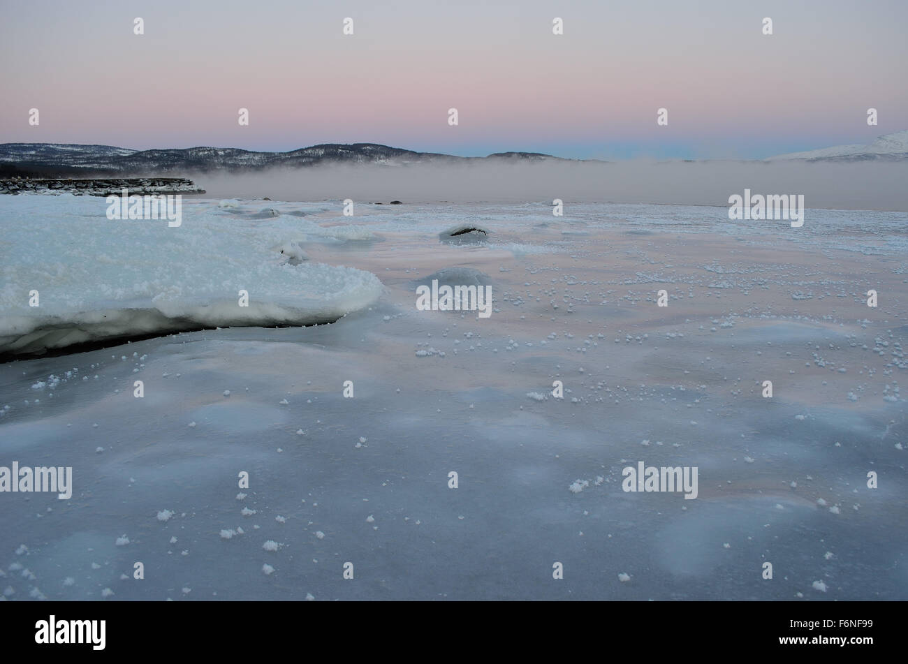 long icy sea with thick ice fog and mist with colorful dawn sky on very ...
