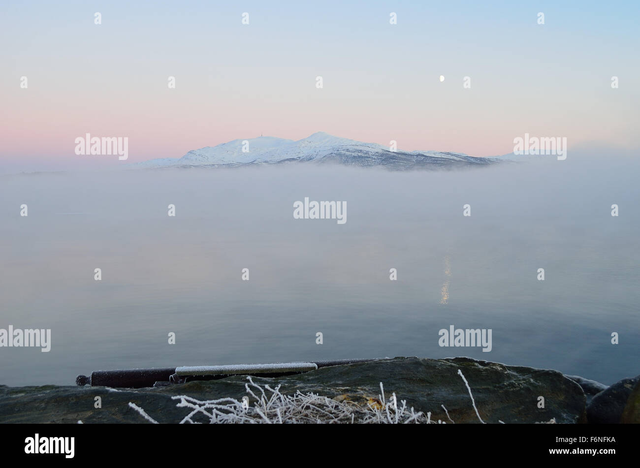 colorful dawn sky over mist and ice shrouded sea landscape in icy cold ...