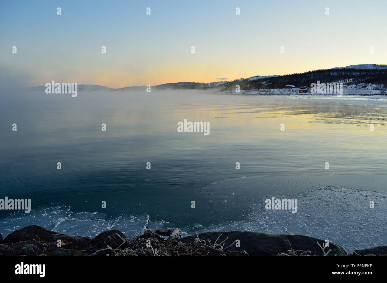 colorful dawn sky over mist and ice shrouded sea landscape in icy cold ...