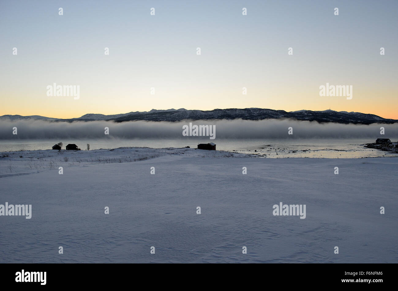 heavy sea ice fog in wintertime over frozen sea shore and colorful dawn ...
