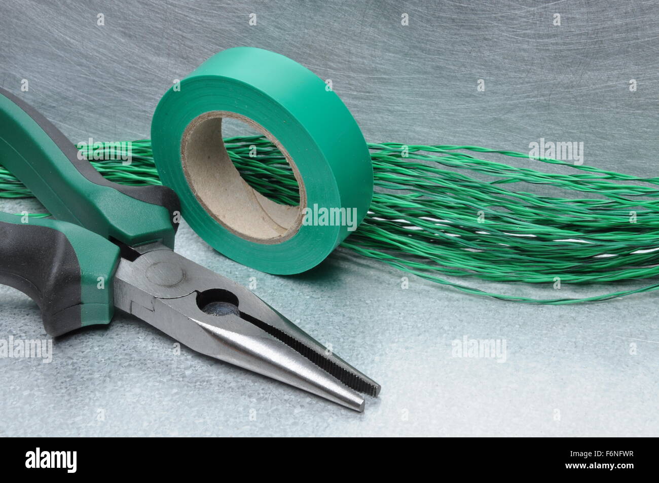 Green electrical tools and cables on metal surface with place for text ...