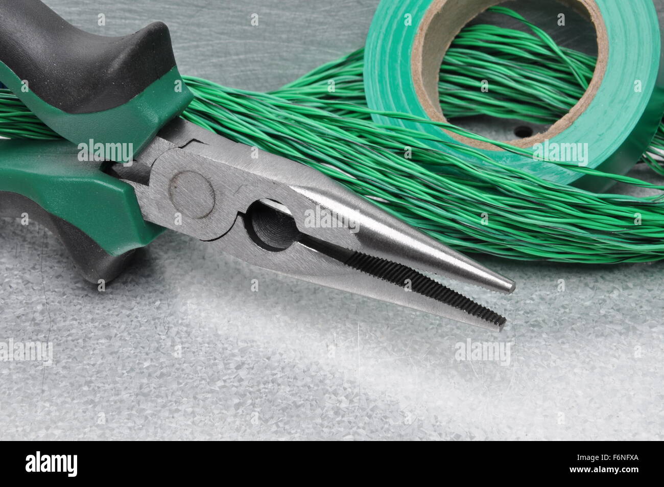Green electrical tools and cables on metal surface with place for text ...