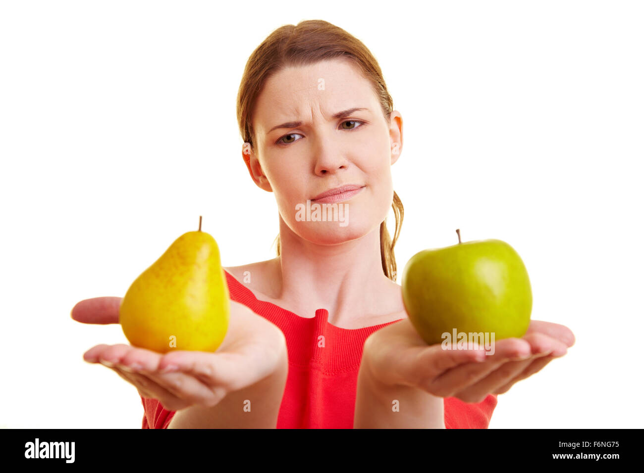 Young woman comparing an apple and a pear Stock Photo - Alamy
